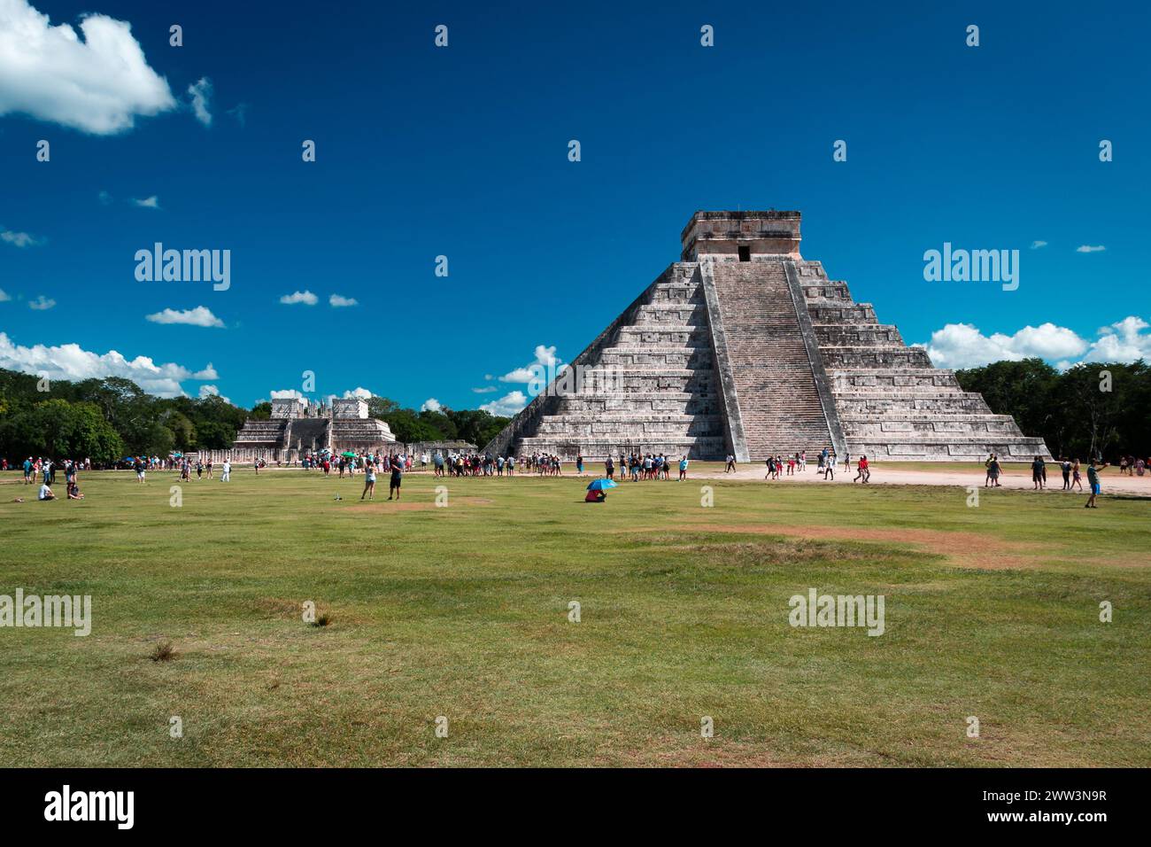 The iconic El Castillo pyramid at Chichen Itza against a bright blue ...