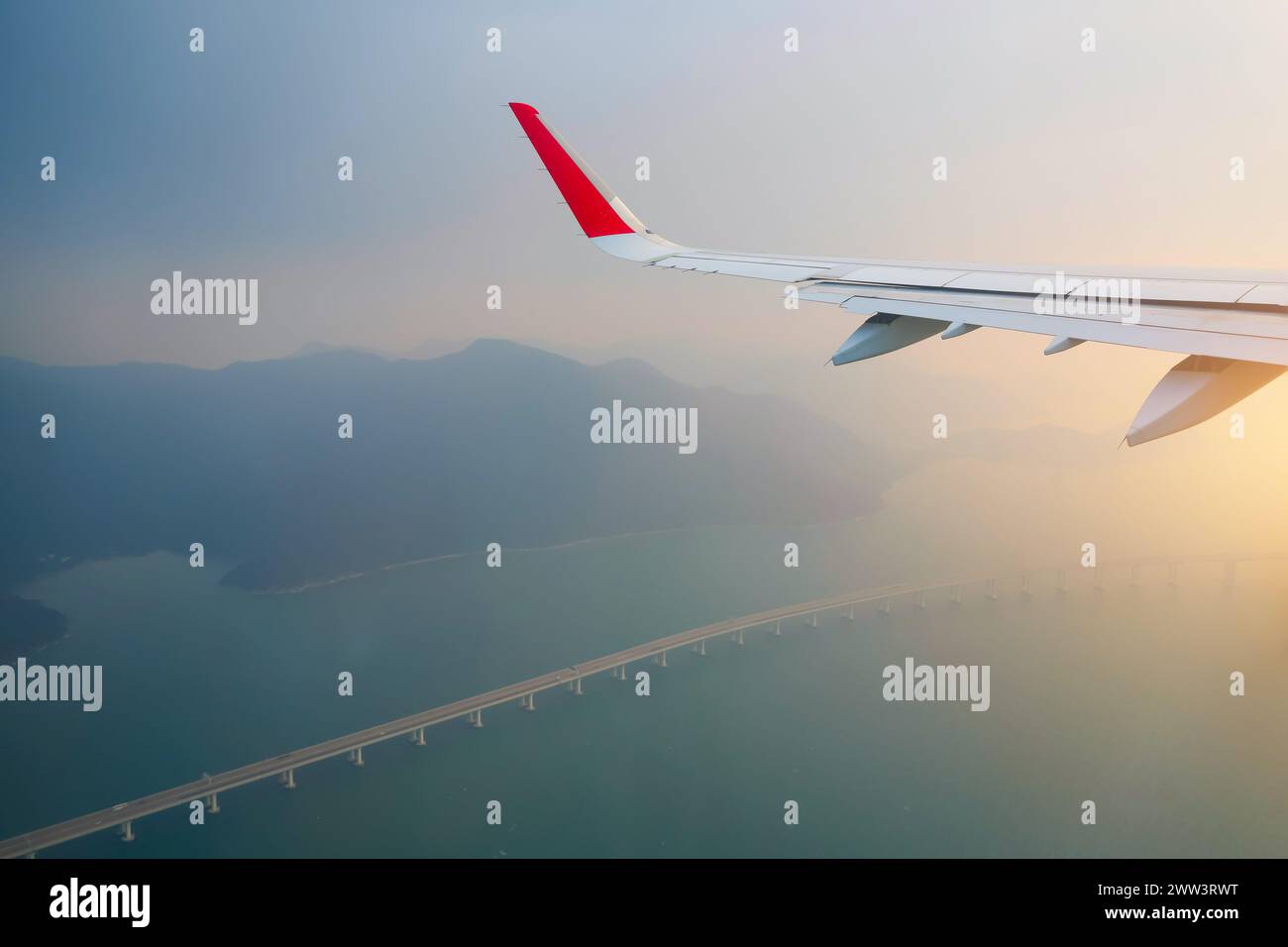 View of an airplane wing and a bridge in the strait during takeoff ...