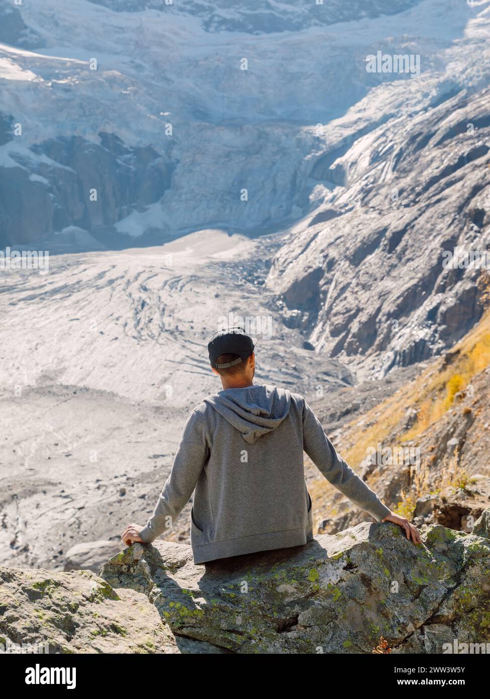 Hiker man sitting on the rock in highest mountains. Mountain with ...