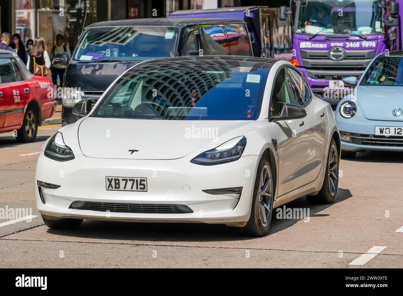 White Tesla car model driving on the city street road. China, Hong Kong ...
