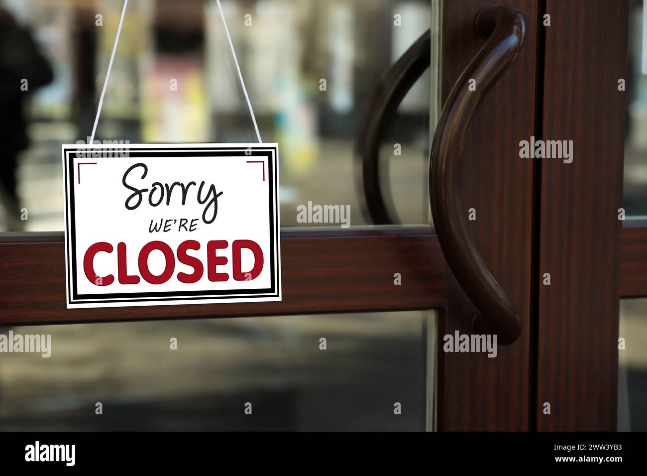 Sorry we are closed sign hanging on glass door Stock Photo - Alamy