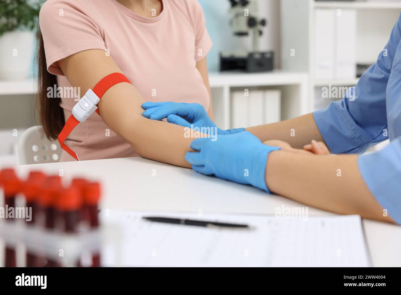 Laboratory testing. Doctor taking blood sample from patient at white ...