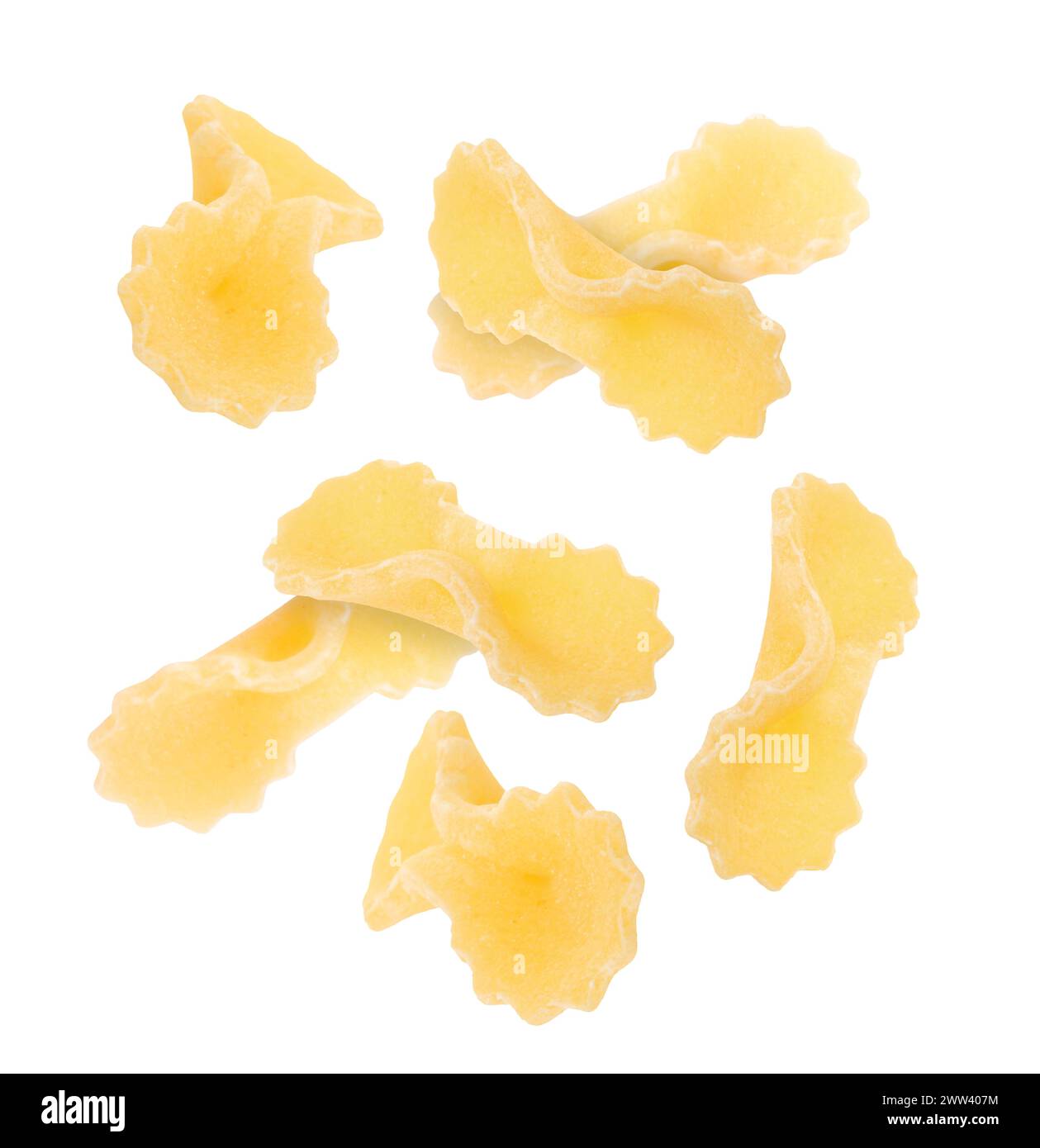Raw farfalline pasta falling on white background Stock Photo - Alamy