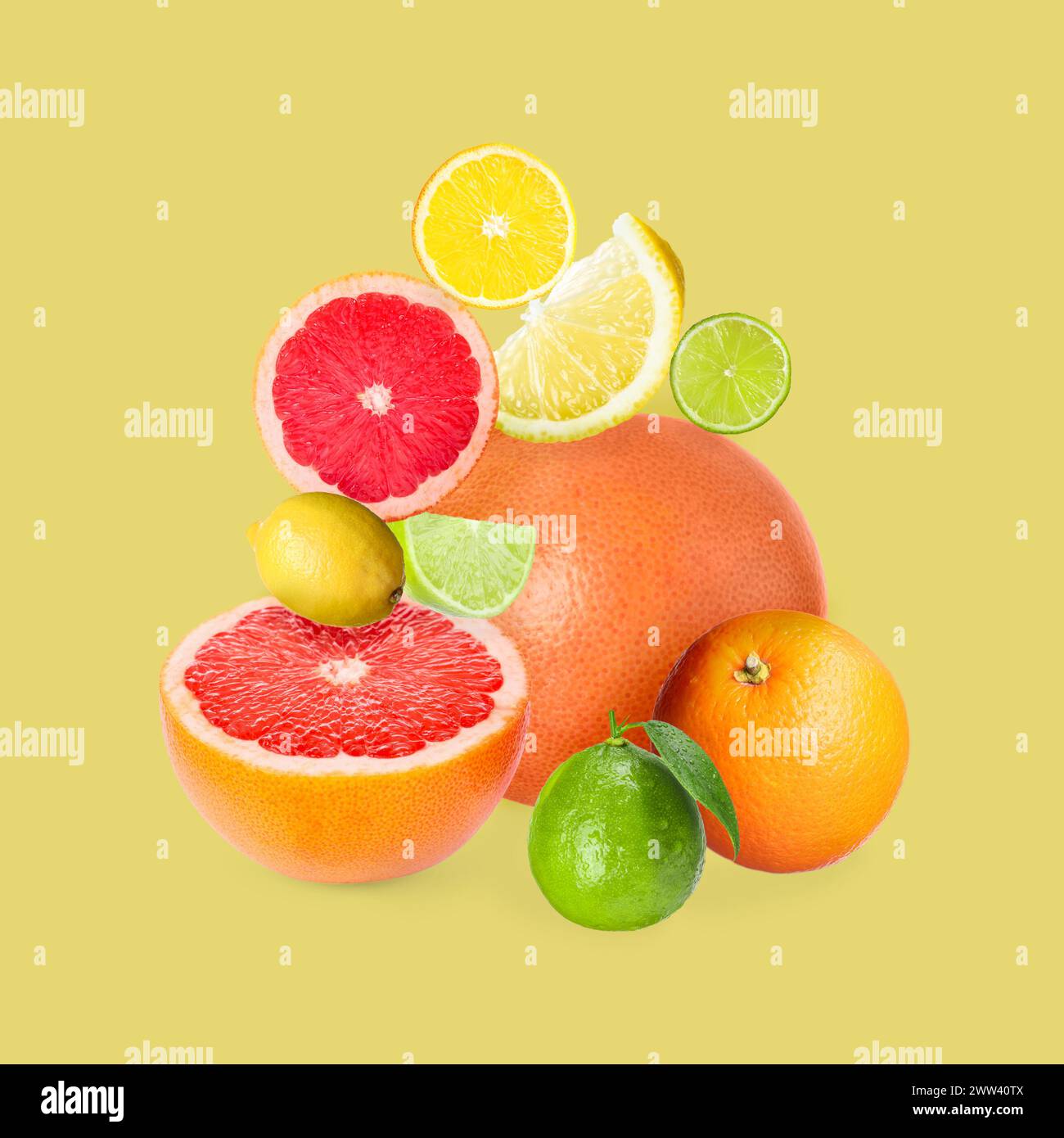 Stack of different citrus fruits on pale yellow background Stock Photo ...