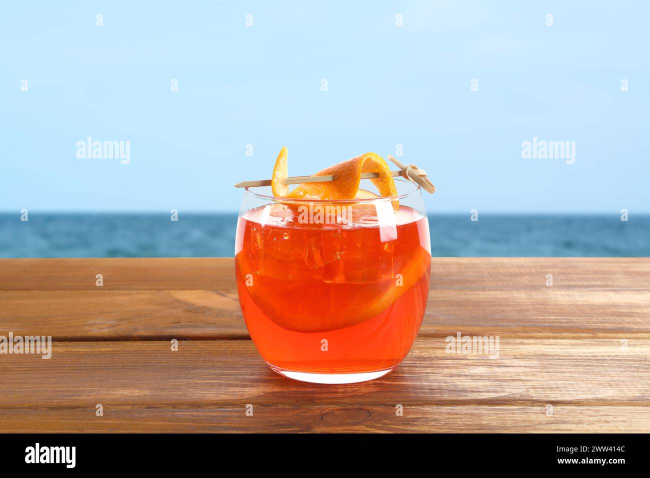 Aperol spritz cocktail with orange slice on wooden table at beach Stock ...