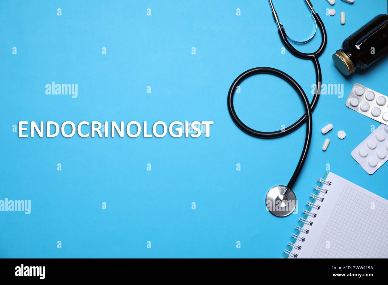 Endocrinologist. Stethoscope, pills and notebook on light blue ...