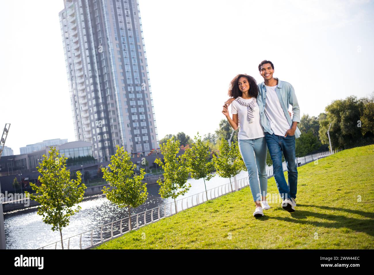Full length portrait of two idyllic cheerful partners cuddle walk green ...