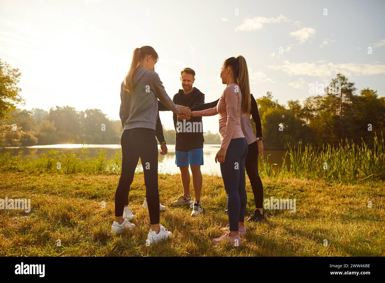 Group of athletes start new day with sports and fold their arms ...