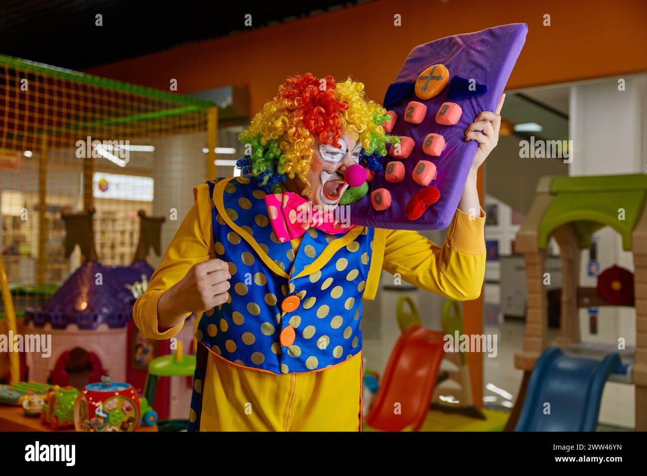 Funny crazy clown talking huge toy phone while entertaining at playroom ...