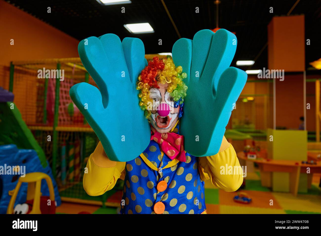 Funny clown with foam hands posing for camera showing happiness Stock ...