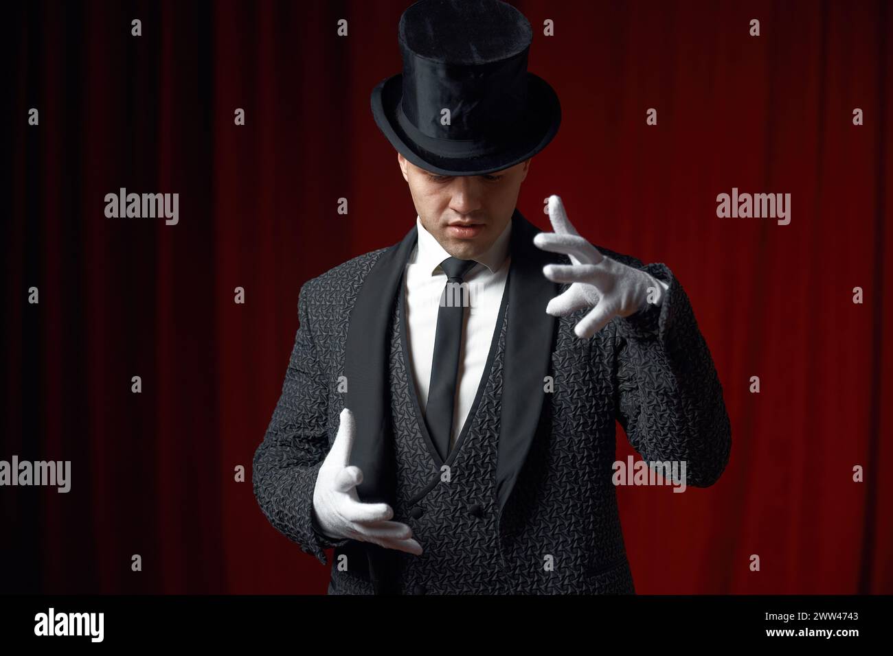 Waist-up portrait of handsome man magician showing mysterious trick on ...