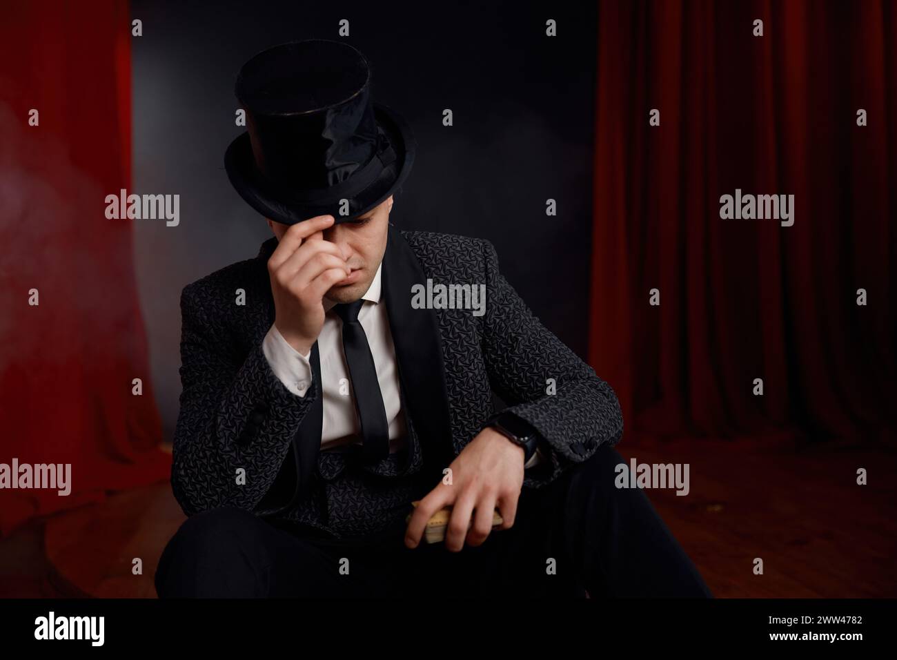 Magician wearing top hat and tuxedo suit holding magic cards in hands ...
