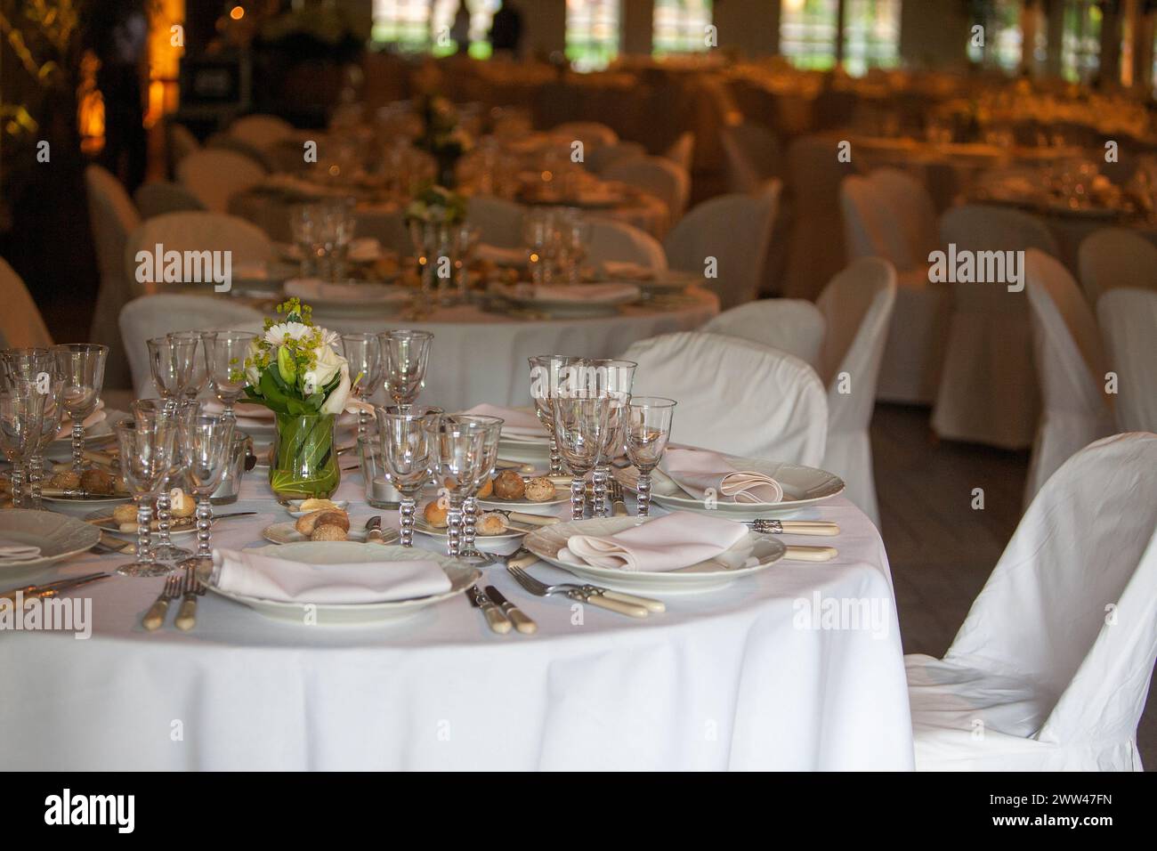 A view across a grand banquet hall adorned with multiple round tables ...