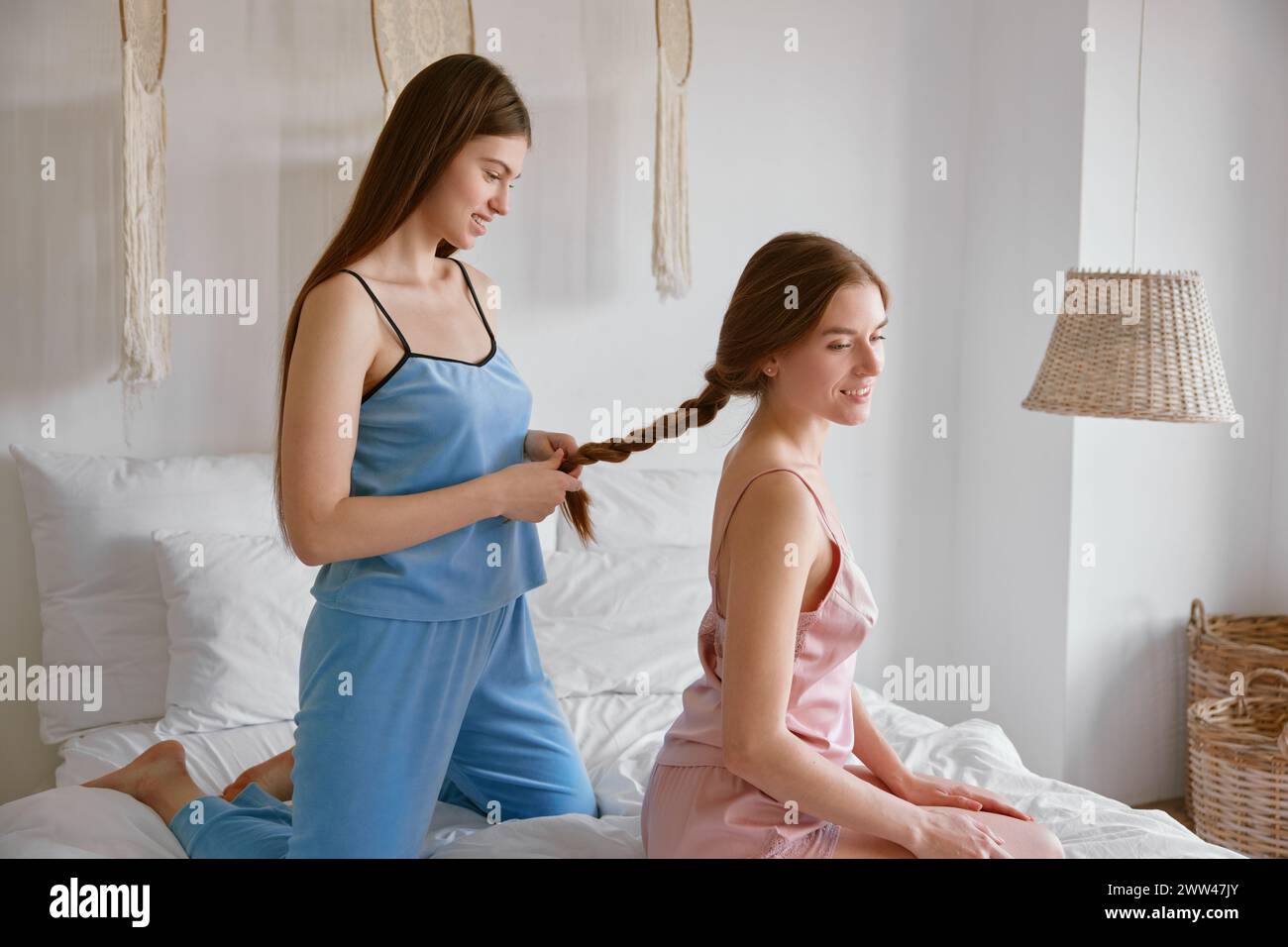 Older sister making hair to her younger female sibling Stock Photo - Alamy
