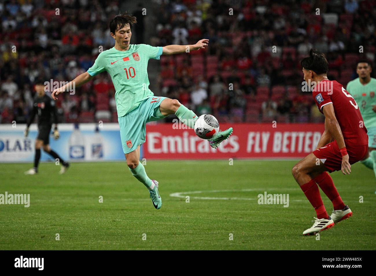 Singapore. 21st Mar, 2024. Xie Pengfei (L) of China controls the ball during the 2026 FIFA World ...