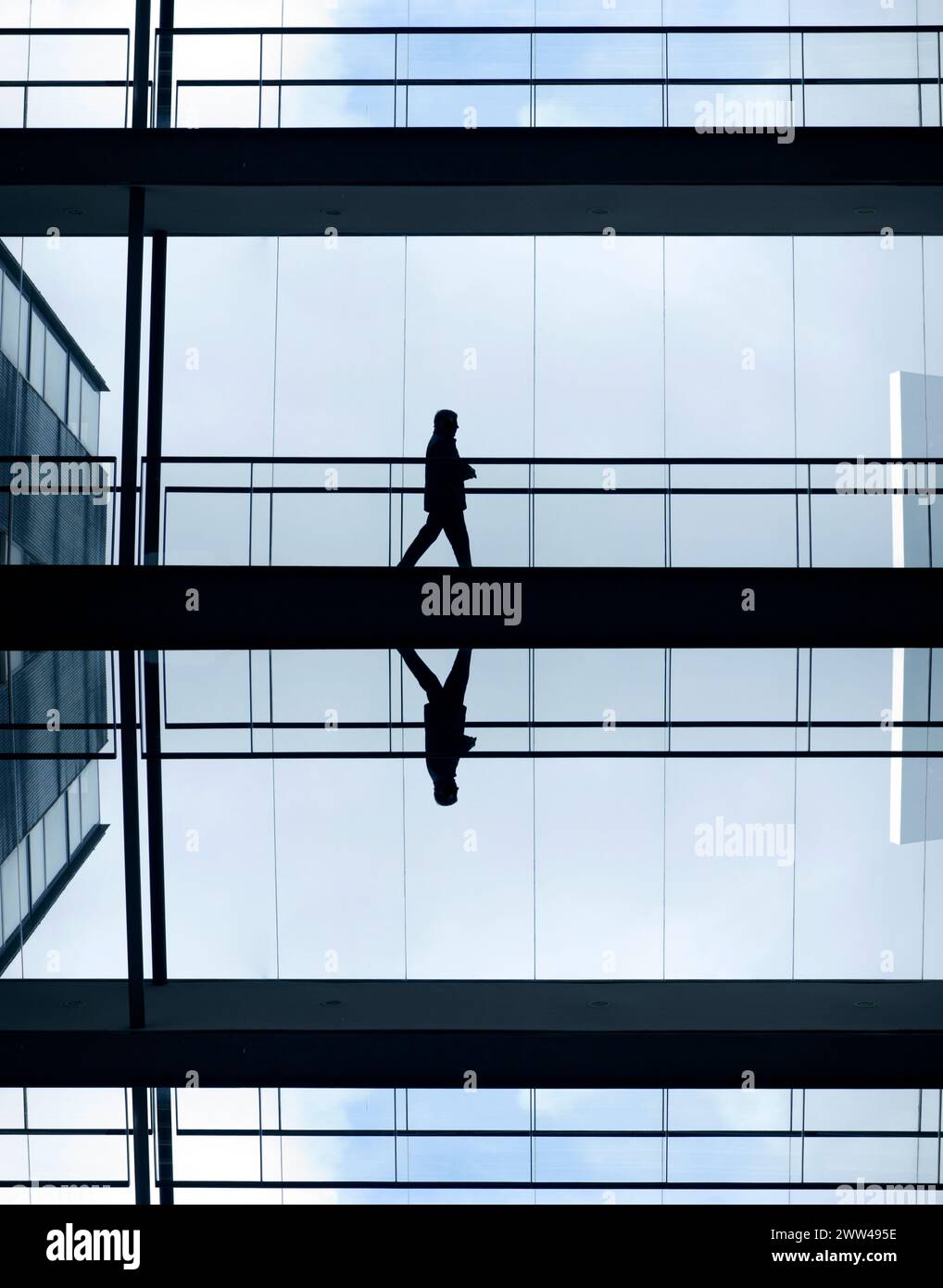 man walking inside a modern office building Stock Photo - Alamy