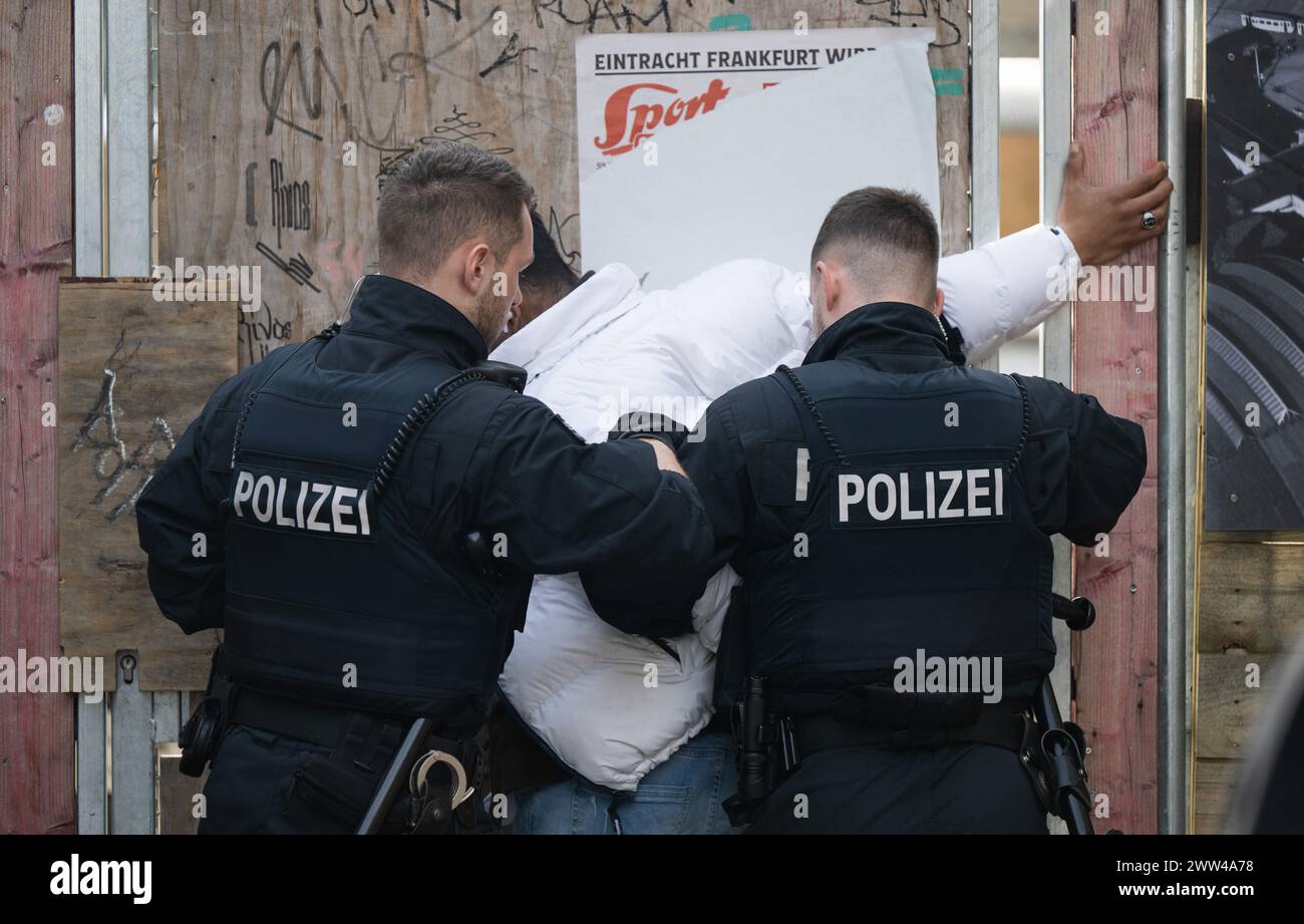 21 March 2024, Hesse, Frankfurt/Main: Police officers search suspects as part of a large-scale ...