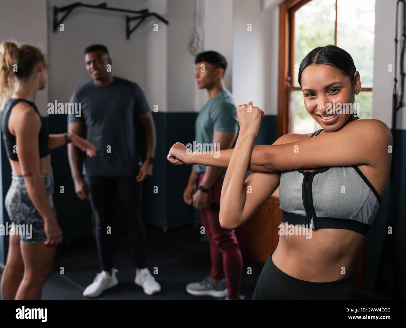 People in gym stretching arms, showing muscle strength, smiling Stock ...
