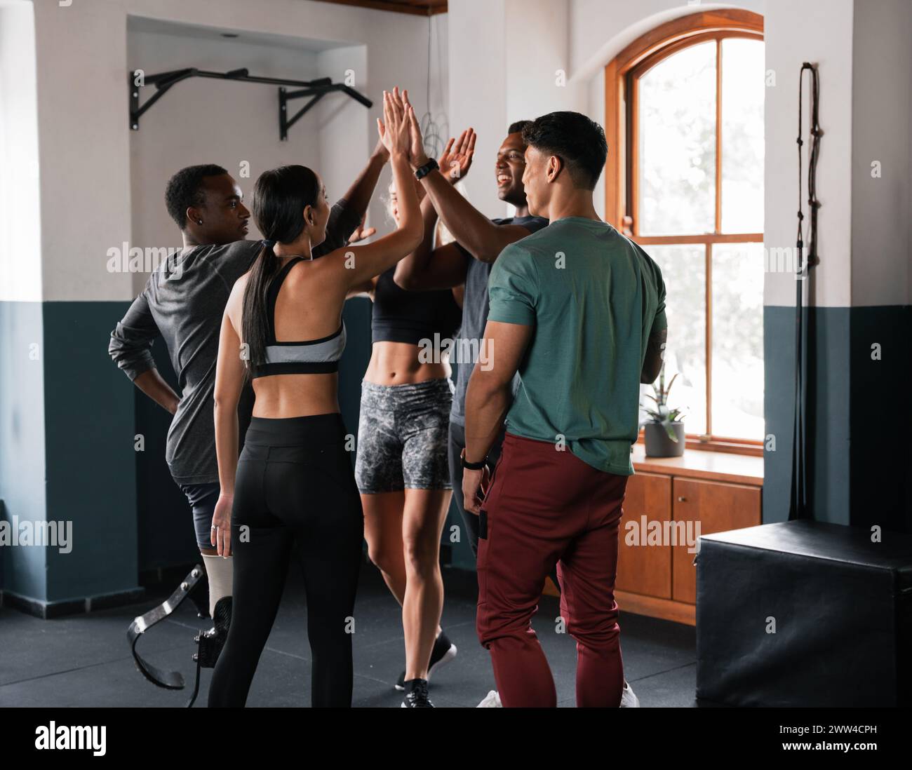 Group in gym high five, celebrating workout event with muscle power and ...