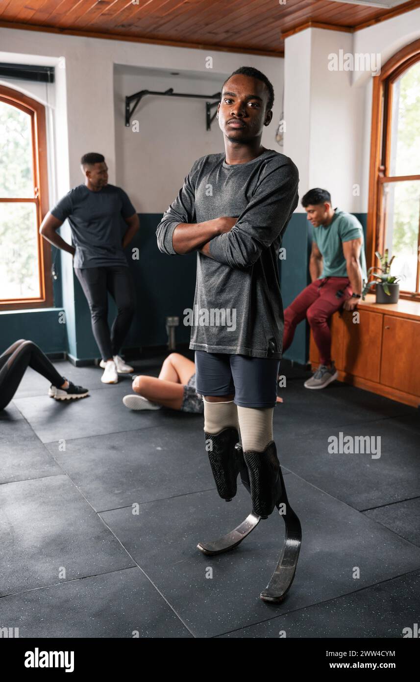 A man with a prosthetic leg stands in the gym, arms crossed Stock Photo ...