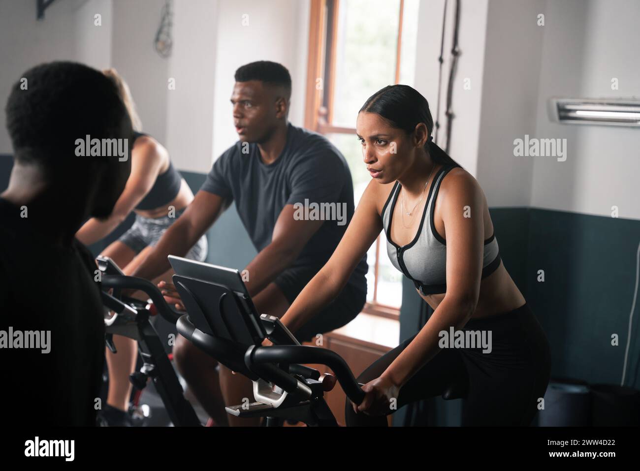 Musclebuilding event in gym, sharing exercise bikes while sitting by ...