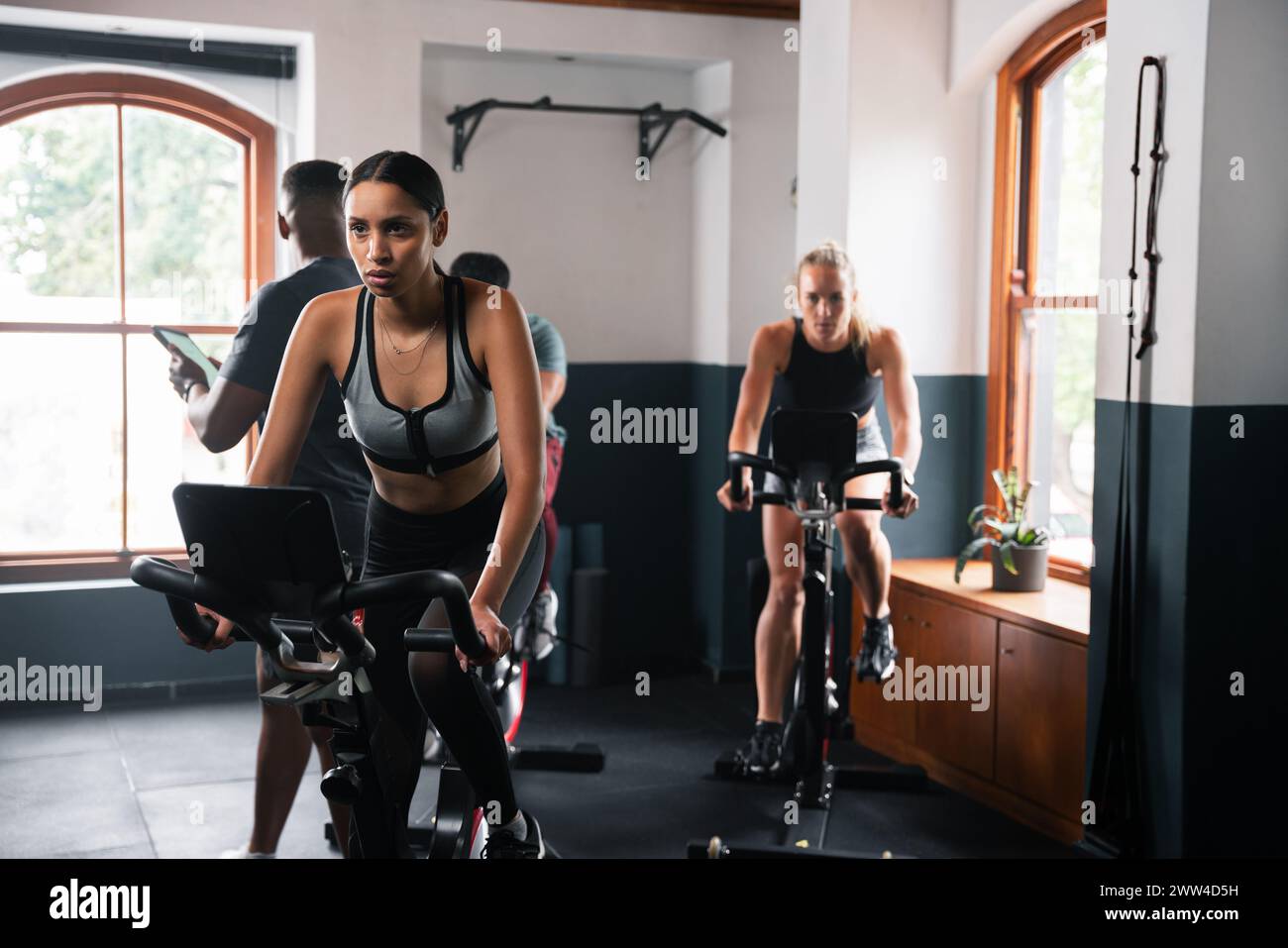 People cycling on exercise bikes in the gym building Stock Photo - Alamy