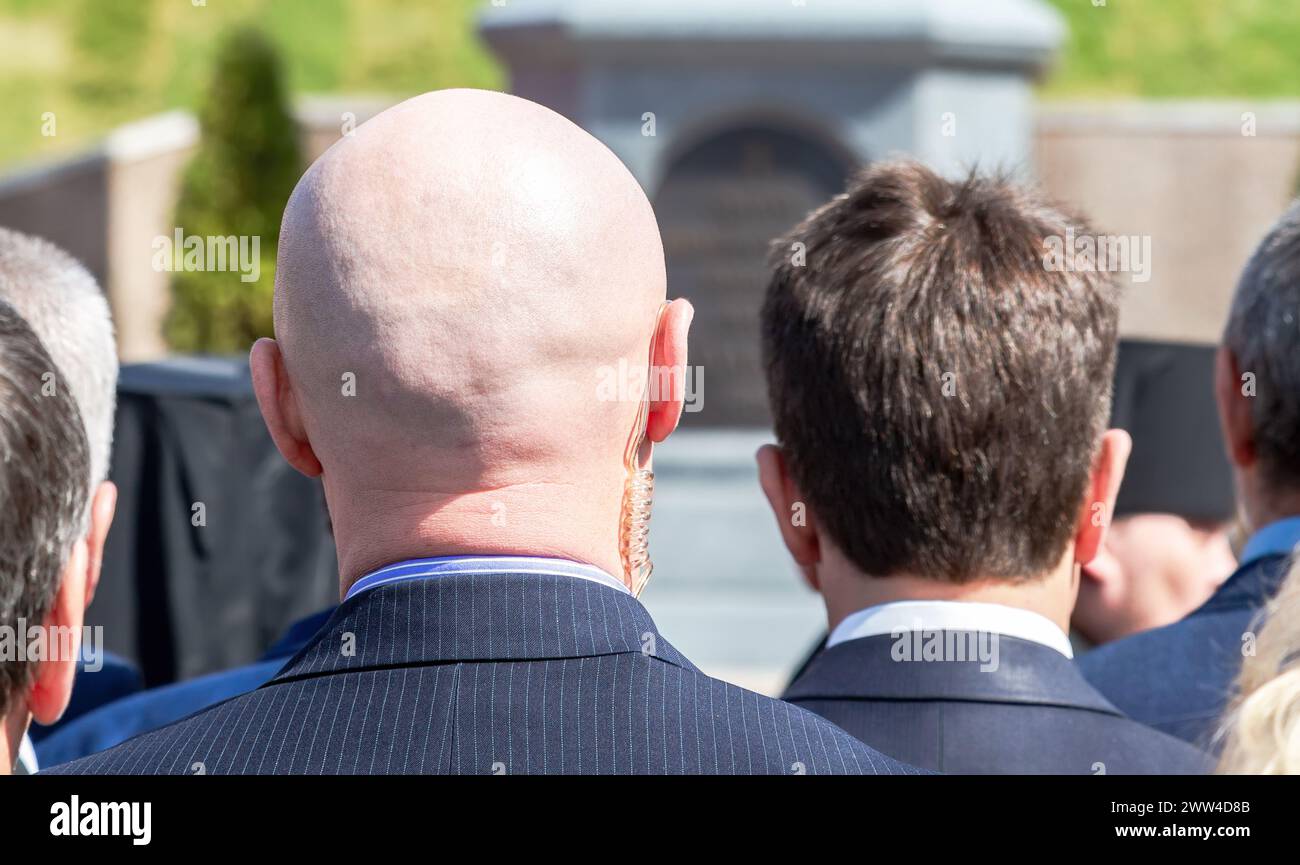 Secret service agent (security guard) with earpiece, behind view ...
