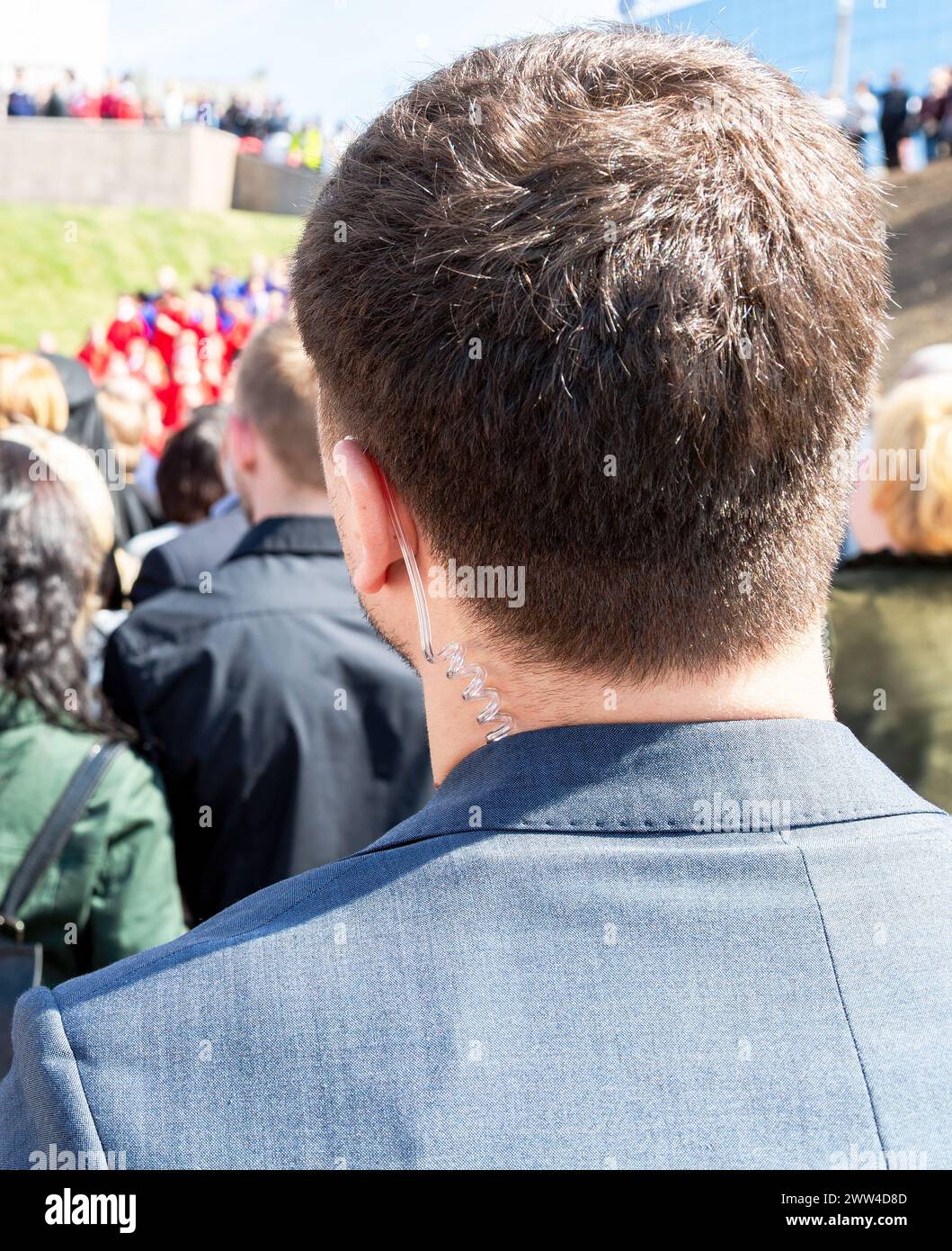 Secret service agent (security guard) with earpiece, behind view ...