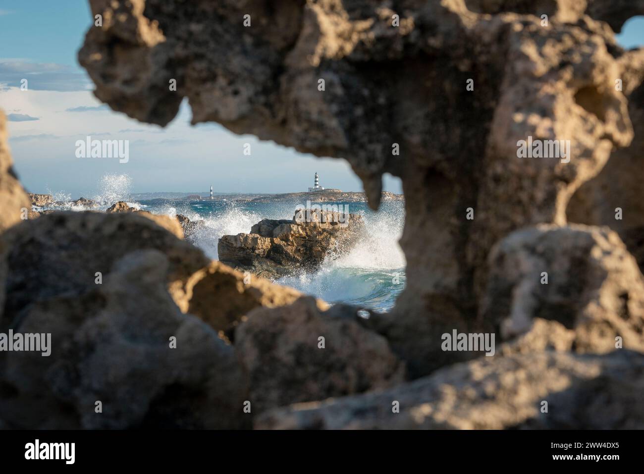 View through an arched rock of En Pou lighthouse at Des Porcs Island ...