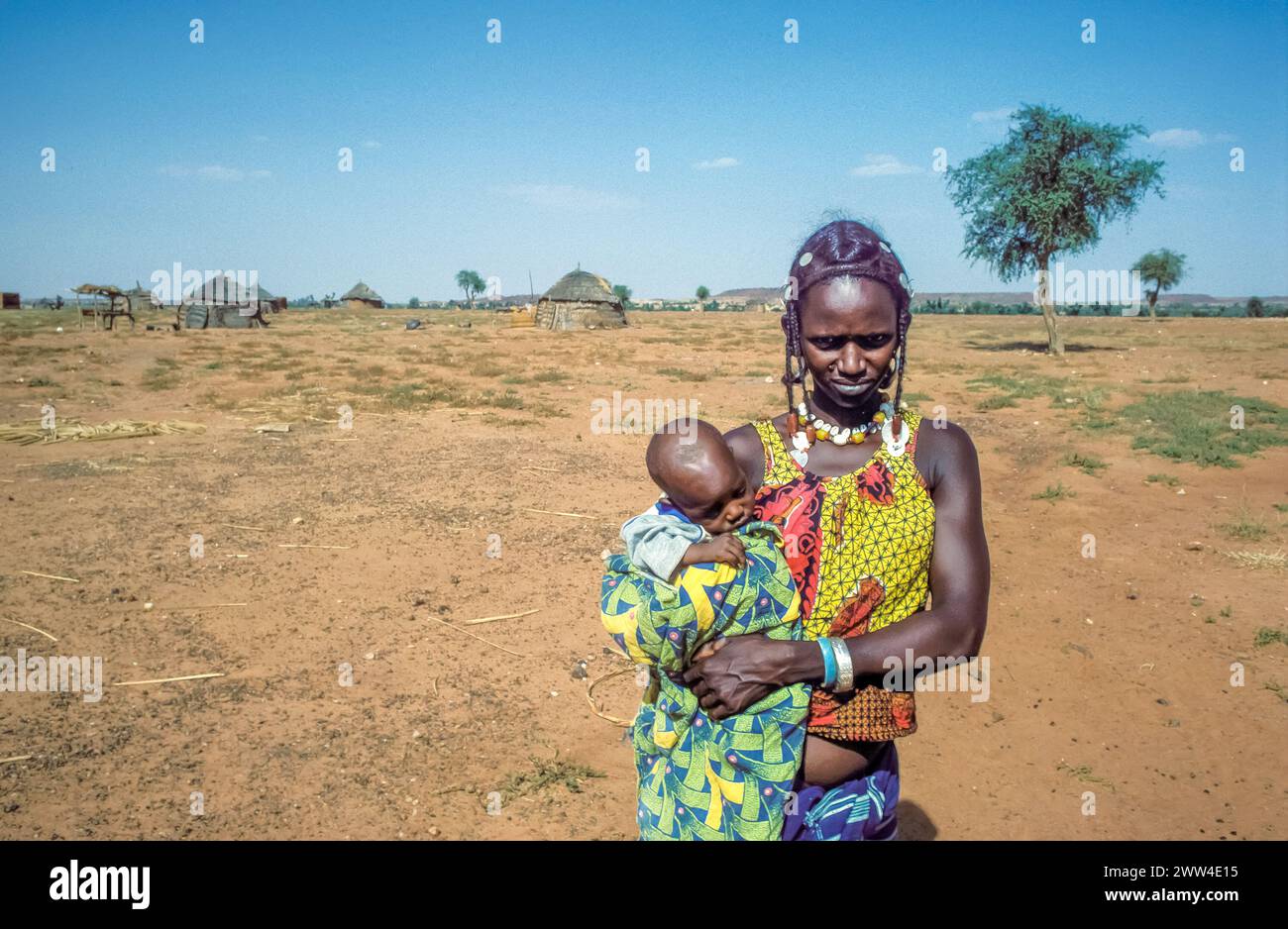 Niger, Tera province, mother and child in front of their hut in an arid ...