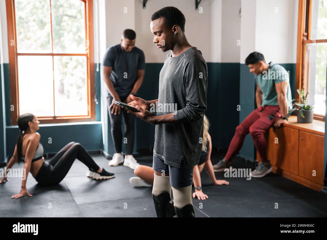 Group of people sharing gym space, building muscle with arm and leg ...