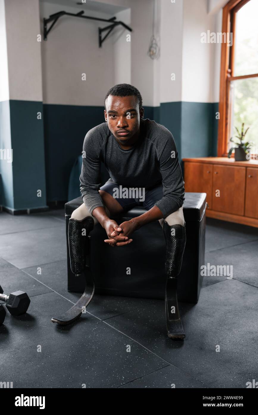 A gym member with a prosthetic leg sits on a chair by a window Stock ...
