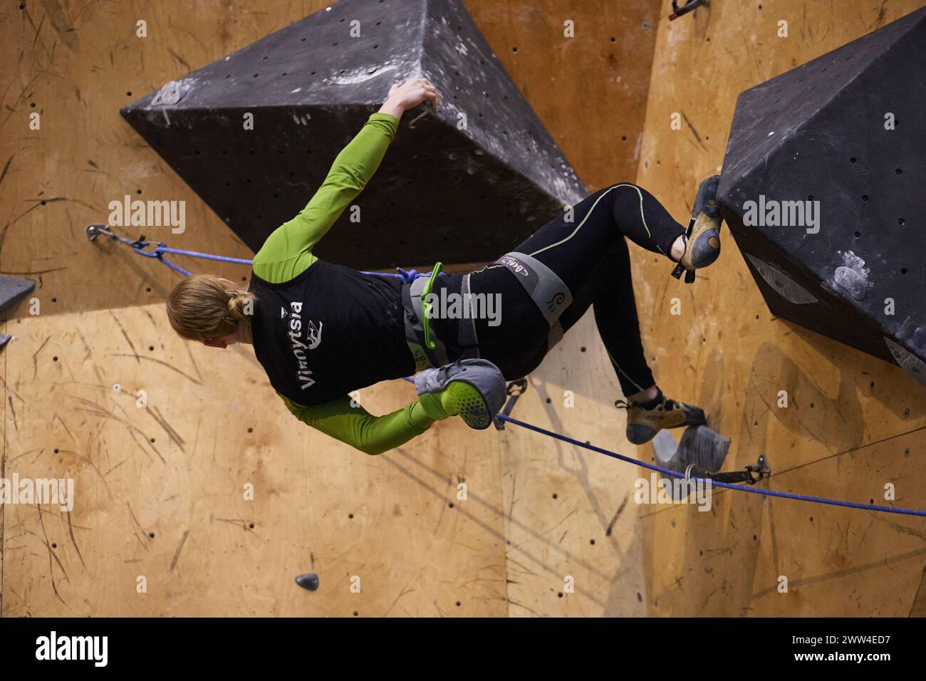 Young climber girl using magnesium powder while climbing the wall. Kyiv ...