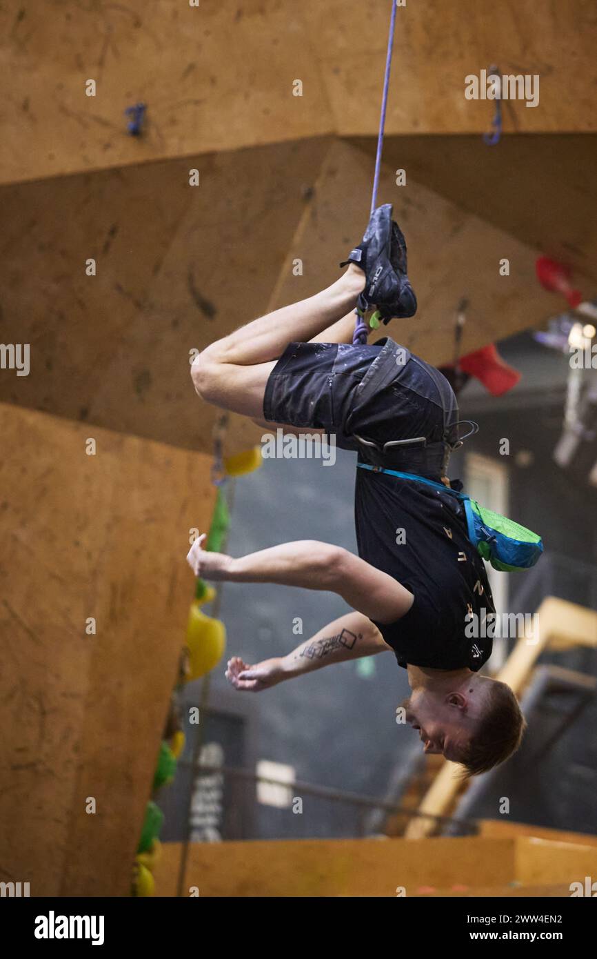 Climber hanging on a safety rope at the indoor climbing competition ...