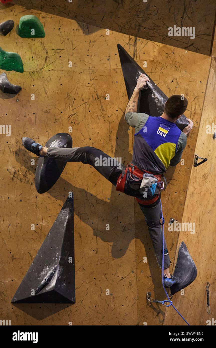 Professional climber hanging on a wall attached to an alpinist harness ...