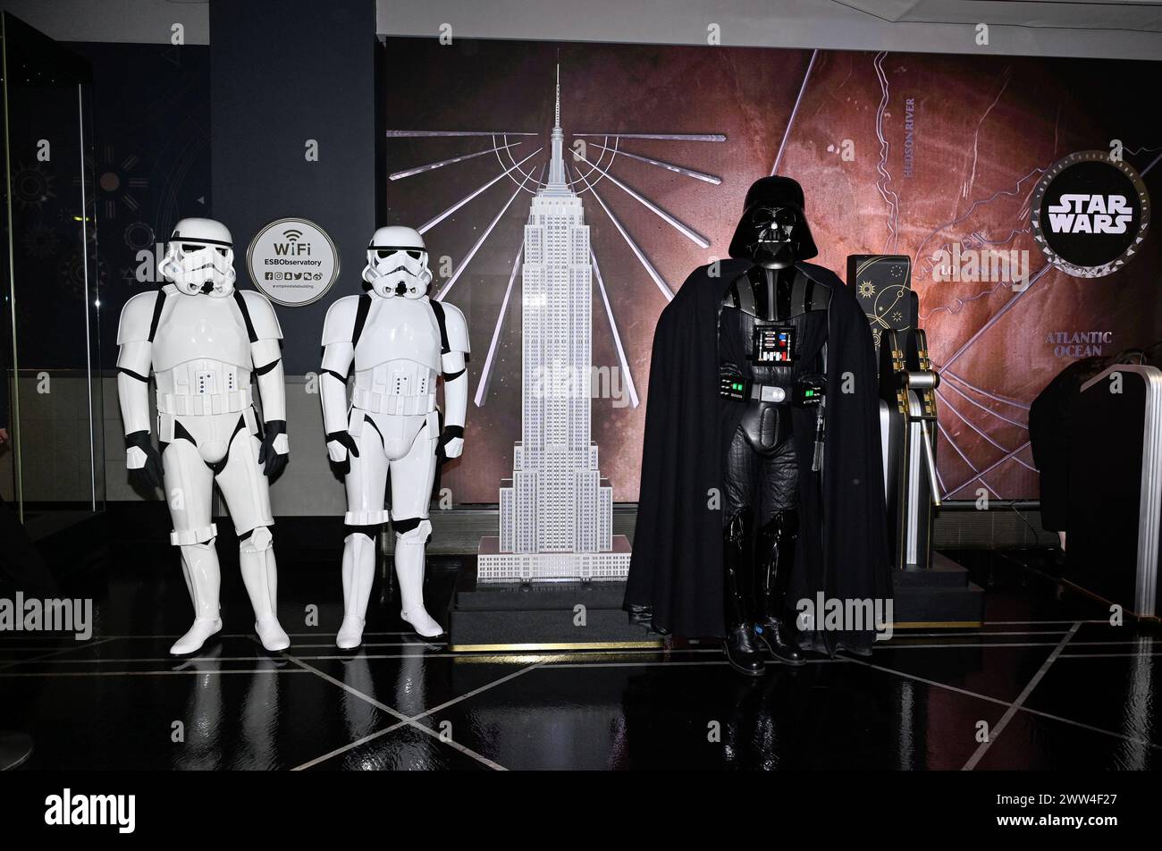 Stormtroopers and a Darth Vader character stand at the ready during a ...