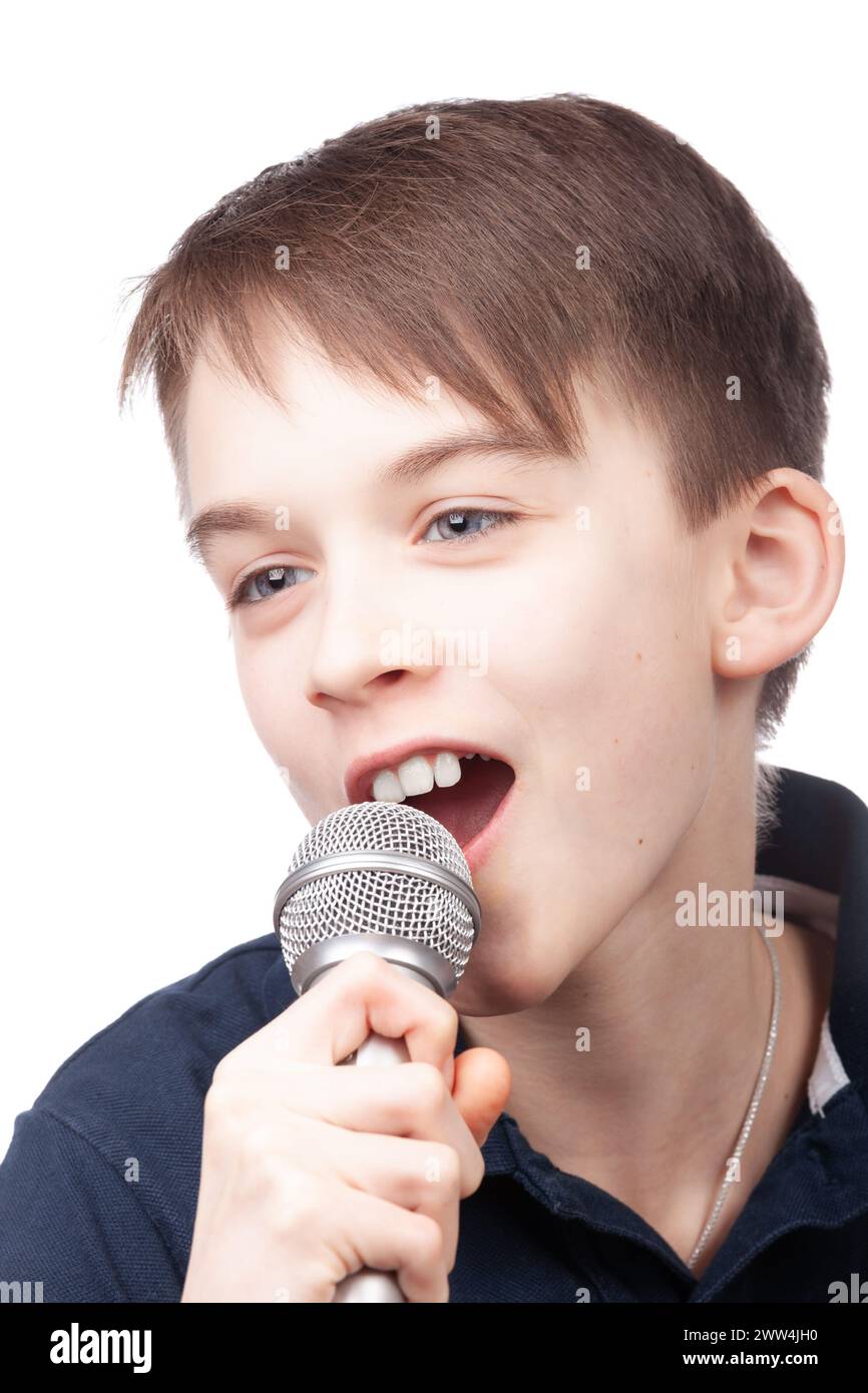 A young boy wearing blue polo shirt singing passionately into a ...