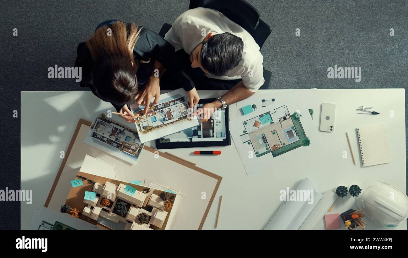 Top view of architect engineer sitting while explain house plan to ...