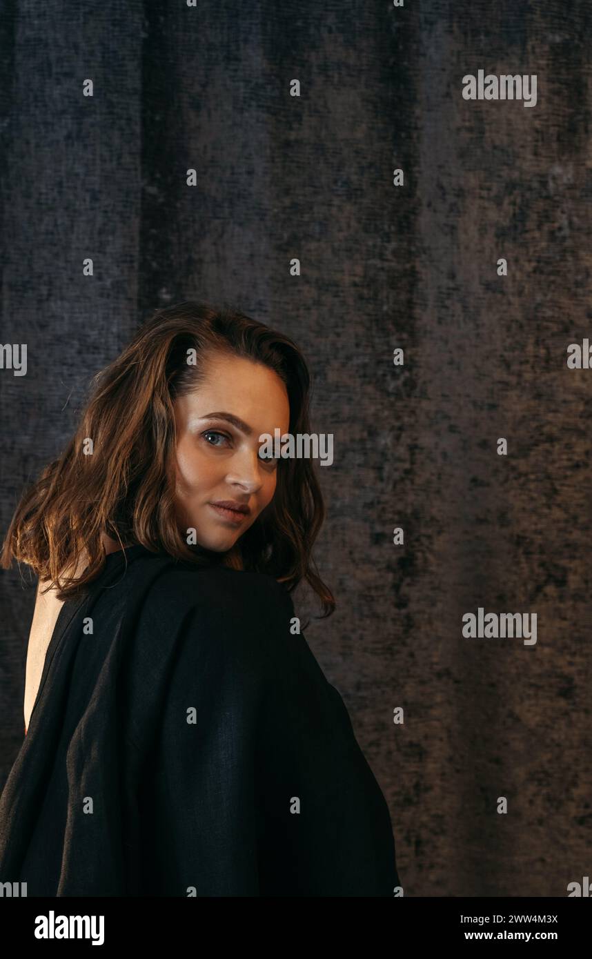 A woman wearing a black top striking a pose for a picture. Vertical ...