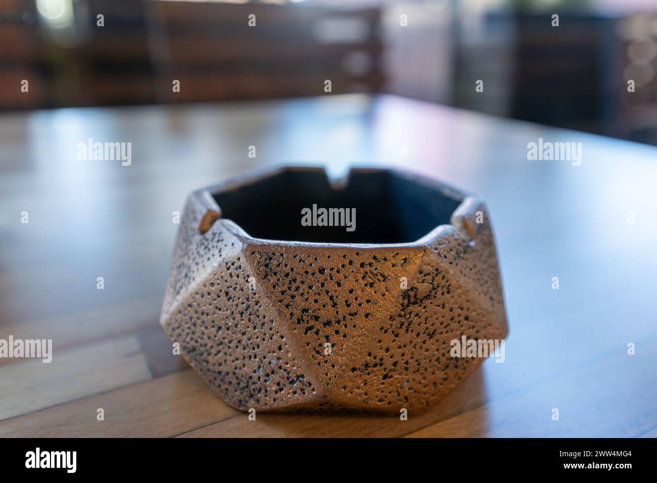 Golden brown edge hexagon shape, empty black ashtray. Table decoration ...