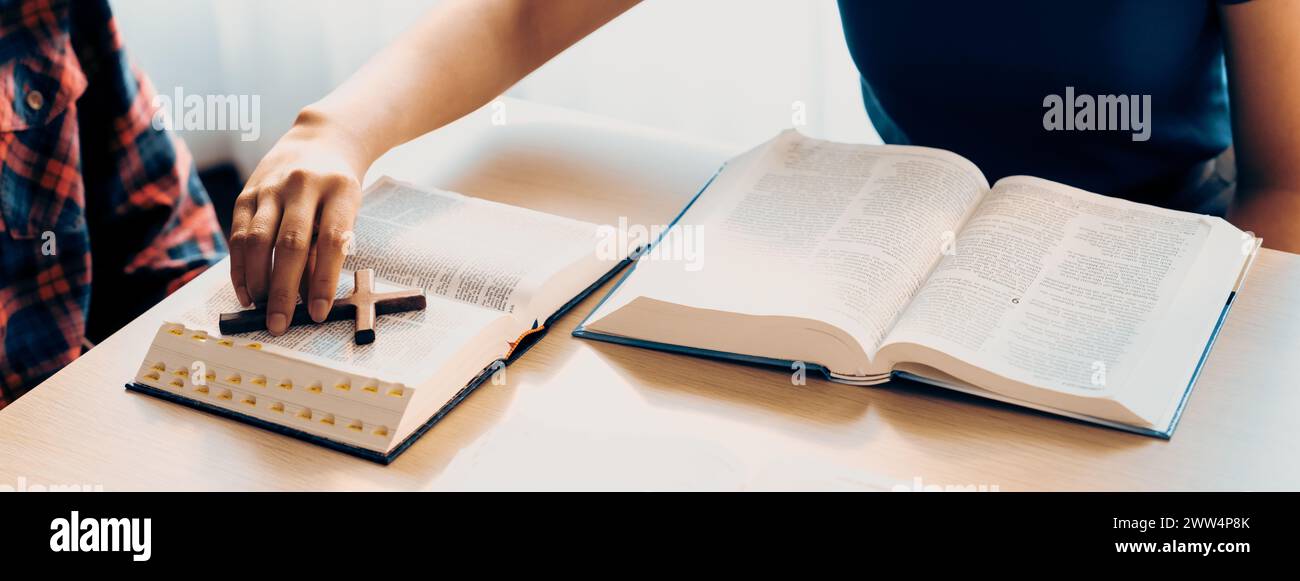Close-up female Christian prayer pickup holy cross on bible book at ...
