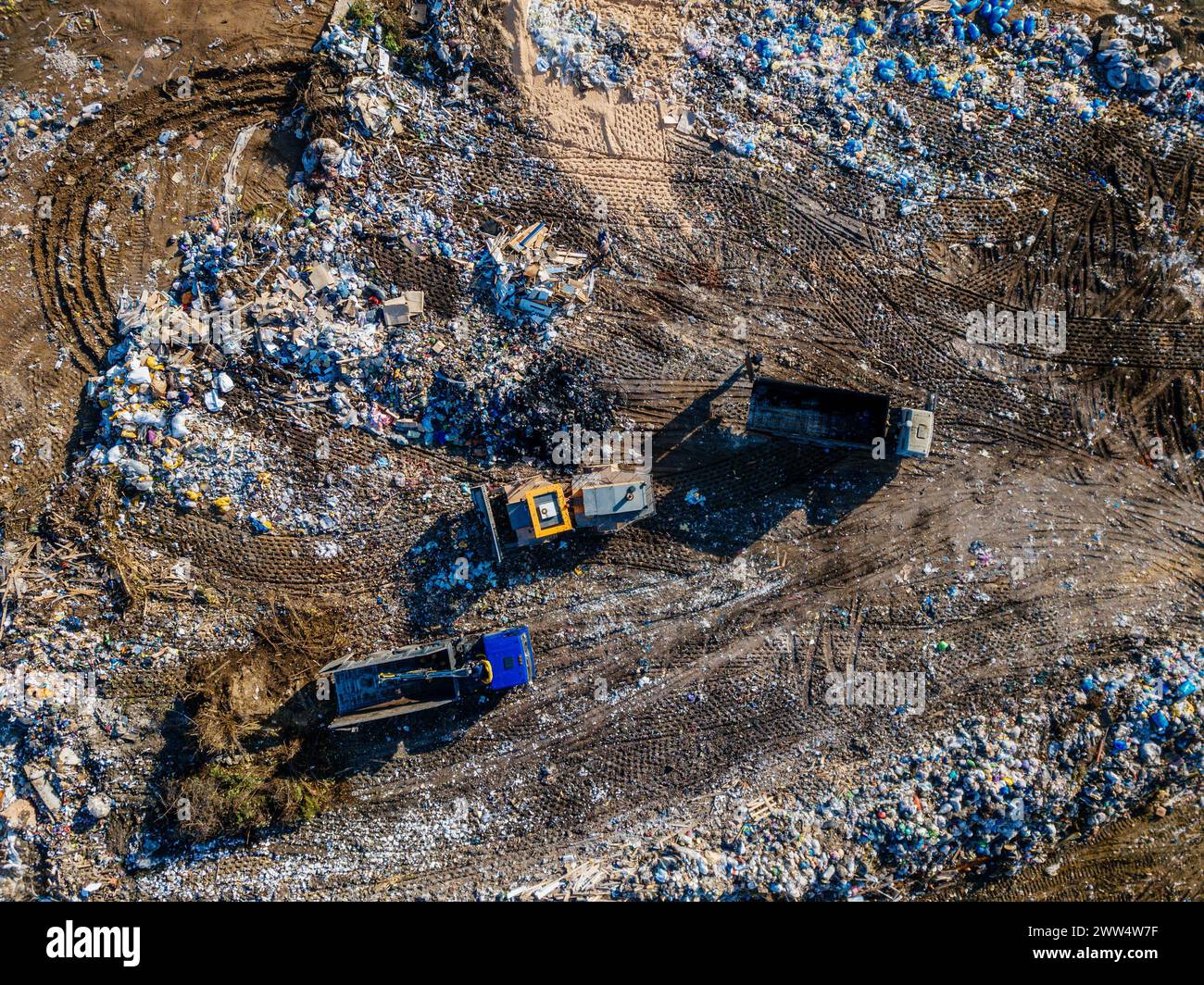 Garbage dump and working dump truck and bulldozer, aerial top view ...