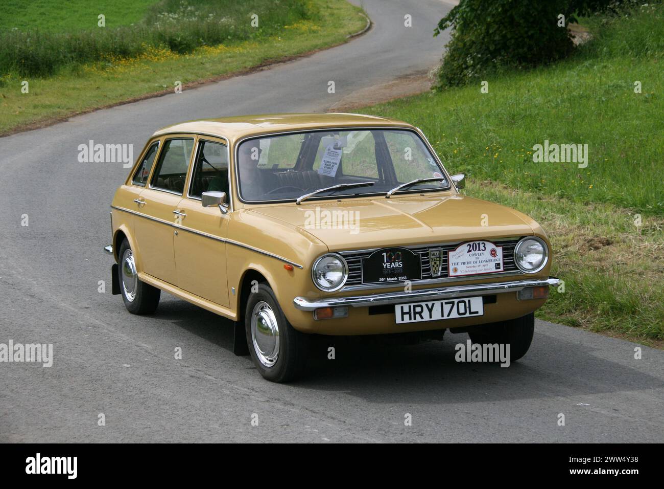 A BEIGE CLASSIC AUSTIN MAXI CAR DRIVING DOWN A COUNTRY LANE Stock Photo ...