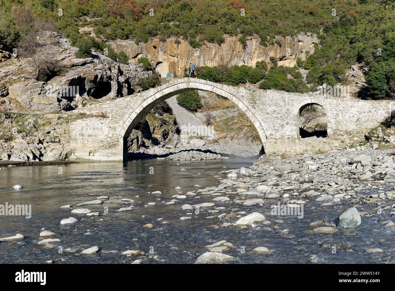 A person crosses the Kadiut Bridge in Benje, Permet, Albania. Stone ...