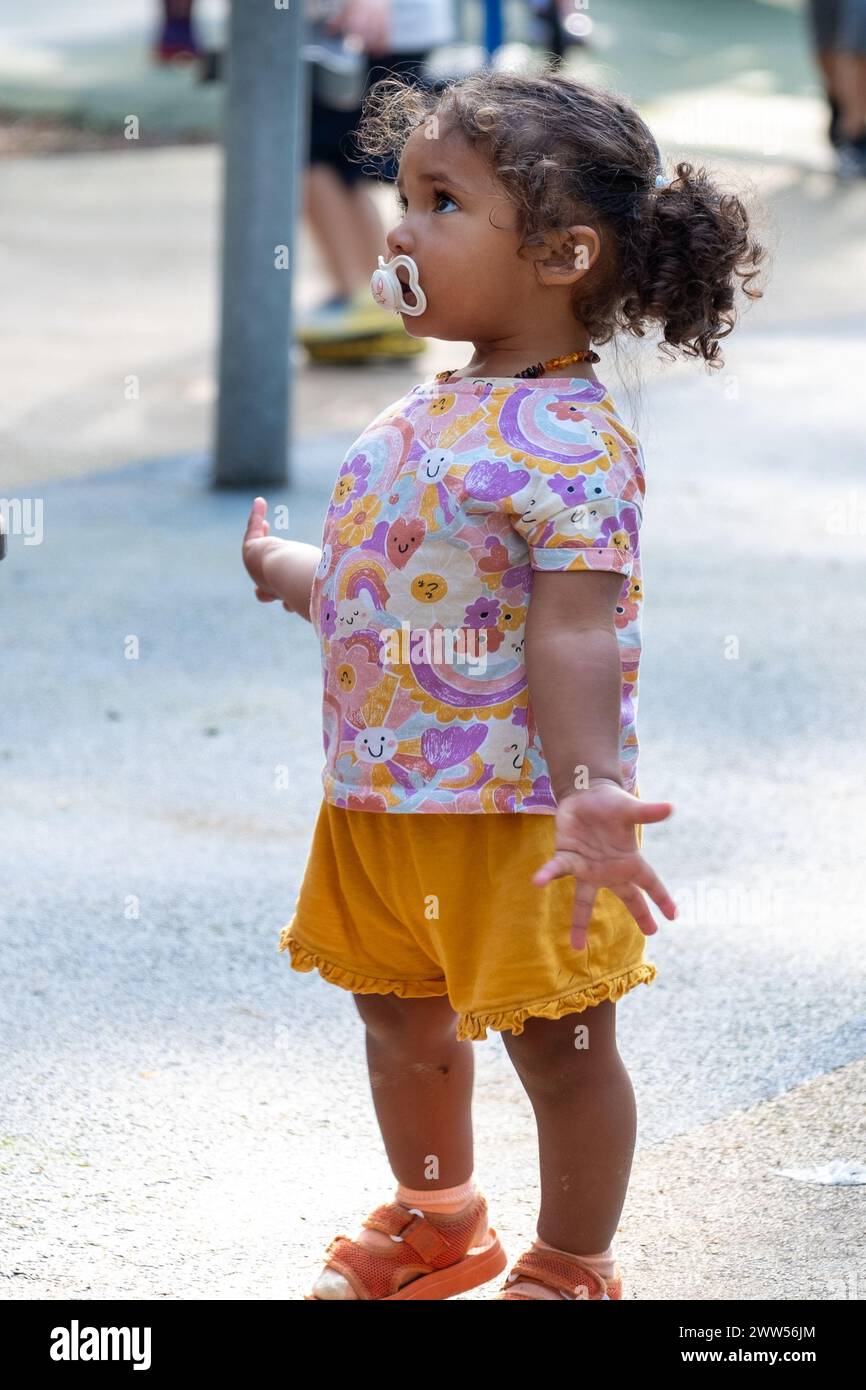 A focused mixed race toddler is looking and questioning something ...