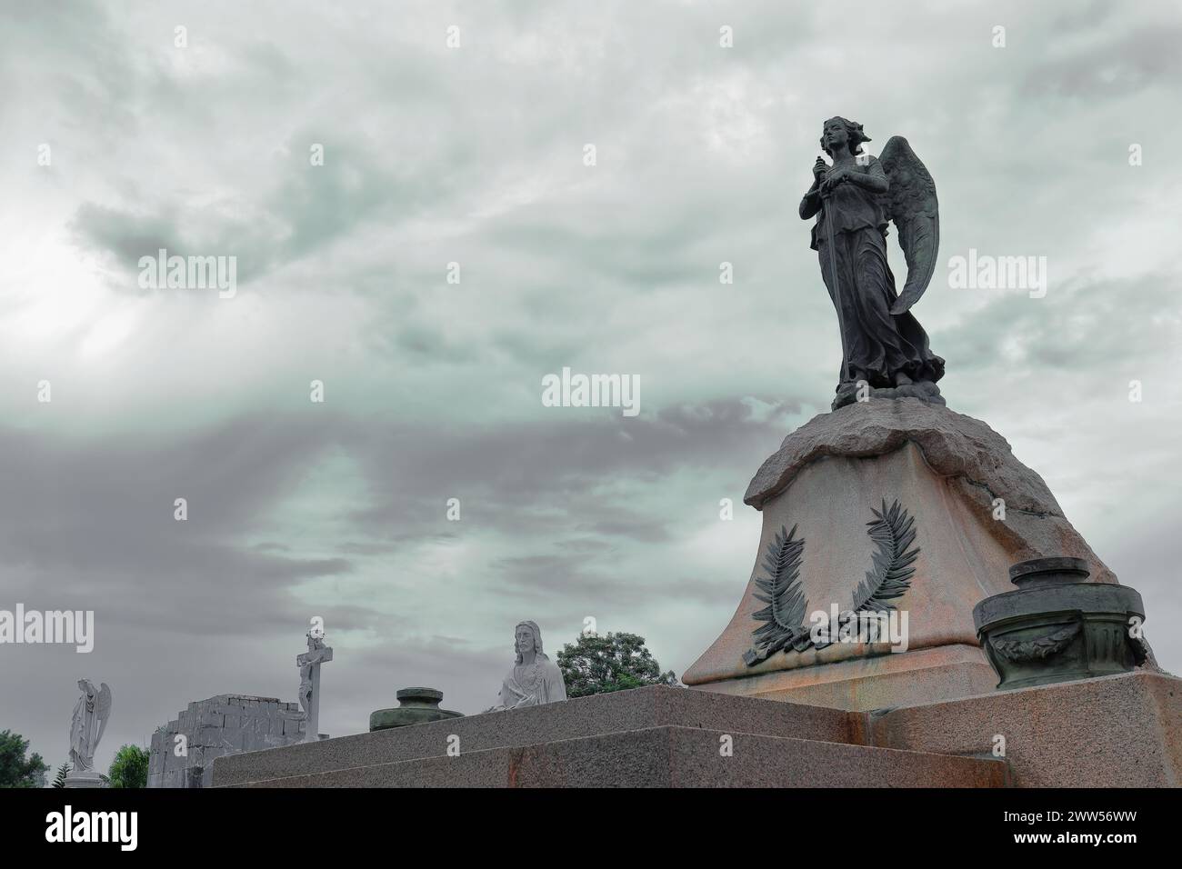 094 Sword-bearing angel and other statues peeking over graves on ...