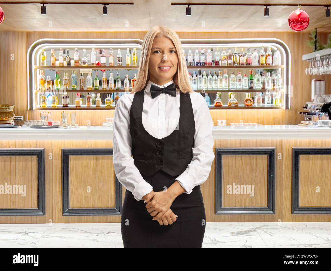 Waitress in a uniform posing in front of a bar Stock Photo - Alamy