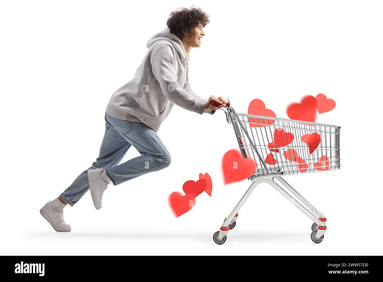 Young man running with hearts in a shopping cart isolated on white ...