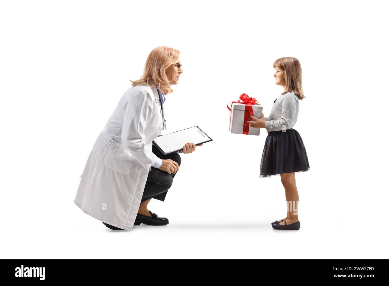 Little girl giving a present to a doctor isolated on white background ...