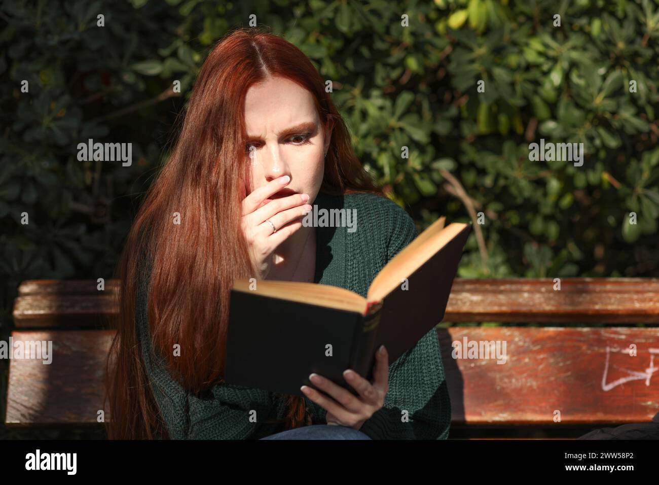 Woman reading such an interesting book and making gestures with her ...